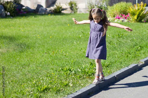 "Little pretty girl walking on the curb with ice cream in hand and ...