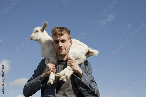 "A man carrying a kid goat on his shoulders" Stock photo and royalty ...