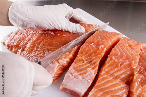 "Cook cut up raw fish in kitchen" Stock photo and royalty-free images ...