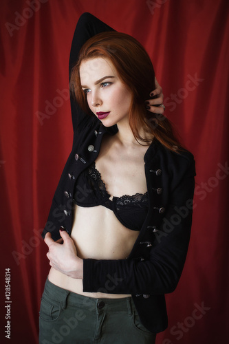 Beautiful Red Haired Girl In Black Lingerie On Red Background Looking