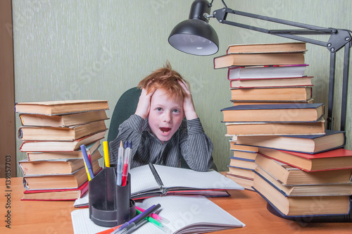 "schoolboy doing homework. the piles of books." Stock photo and royalty ...