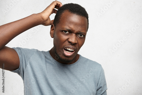 Headshot Of Clueless Perplexed Young African American Man In Grey T