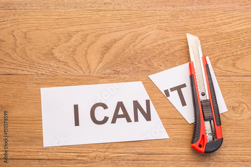 Red Cutter Blade Cutting Word I CAN T In White Paper On Brown Wooden Plank Stock Photo And red-cutter-blade-cutting-word-i-can-t-in-white-paper-on-brown-wooden-plank-stock-photo-and