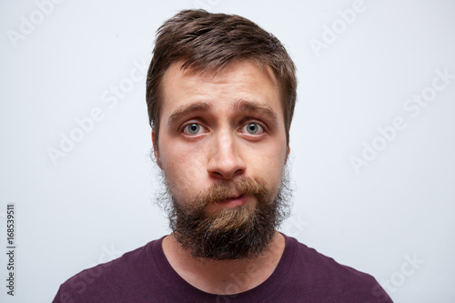 "Young bearded man uncertain what to do with his messy beard and ...