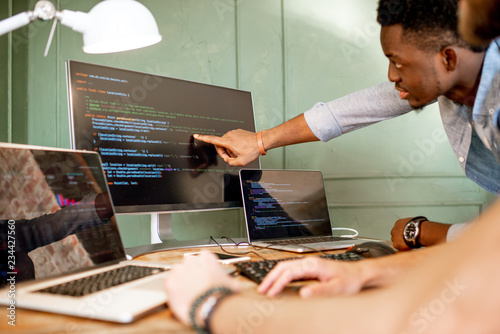 "Two young programmers working with program code sitting at the ...