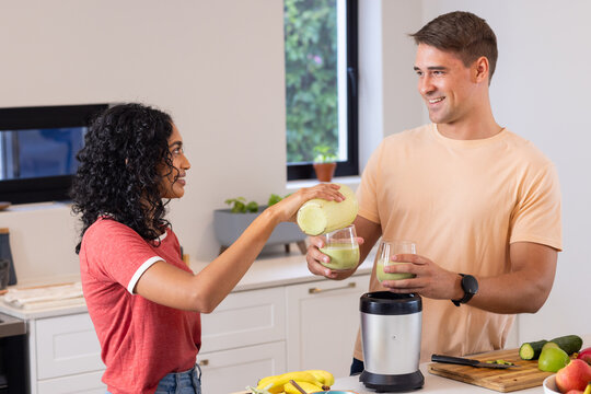 Couple Making Fresh Fruit Smoothies Together in Modern Kitchen
